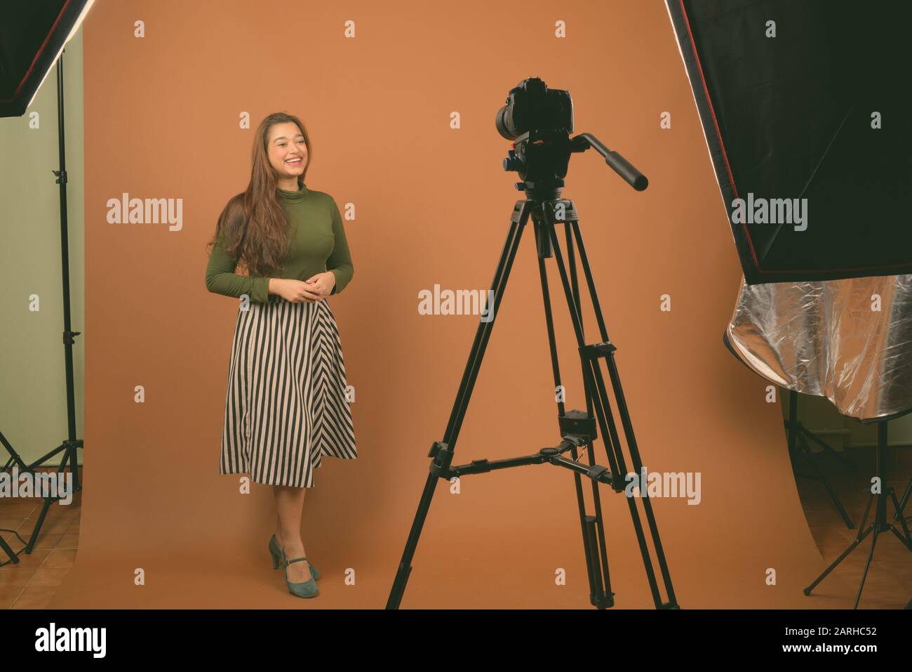 Young beautiful Indian woman vlogging against brown background Stock ...