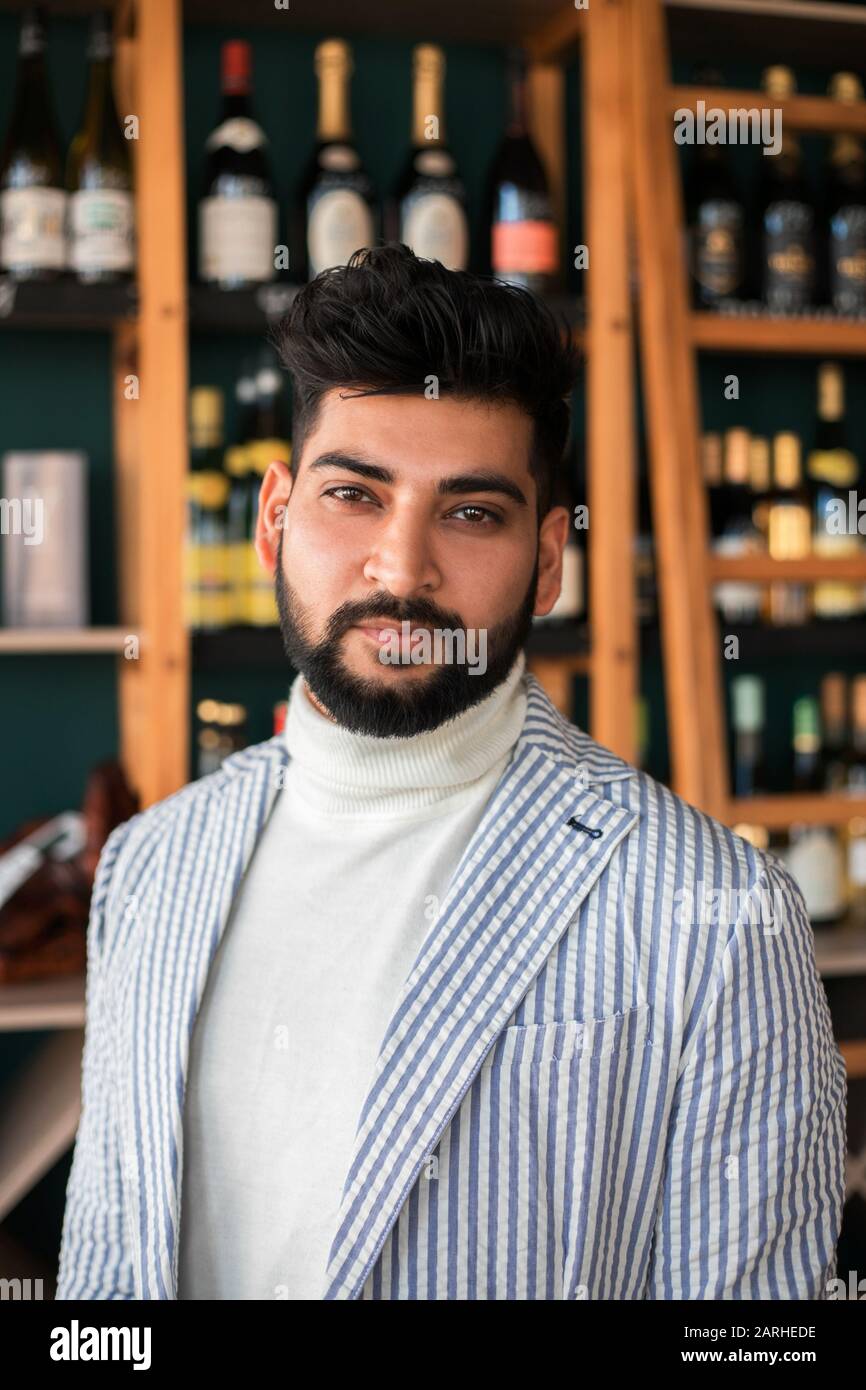 Handsome elegant Indian man against wall of wine bar Stock Photo - Alamy
