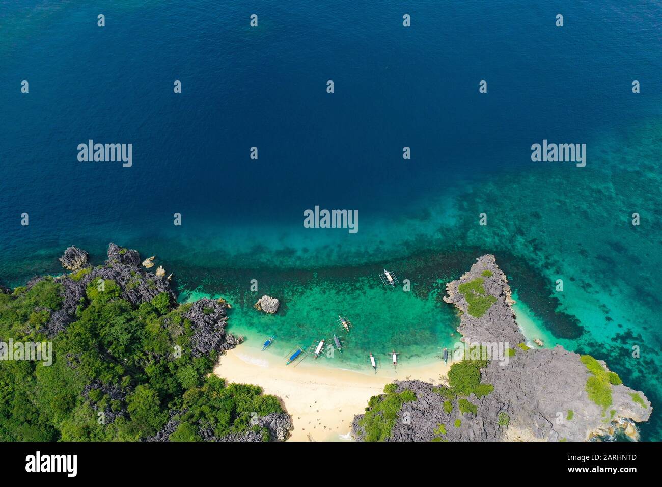 Top view of small tropical island with white sandy beach and blue ...