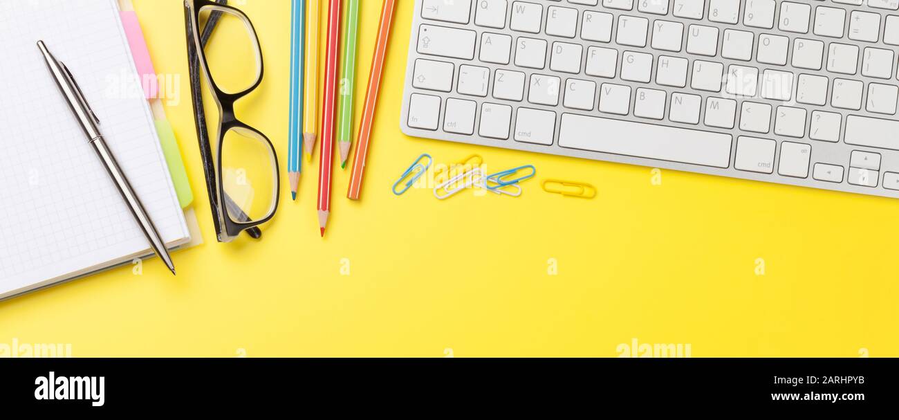 Office yellow workplace backdrop with supplies and computer. Wide flat ...
