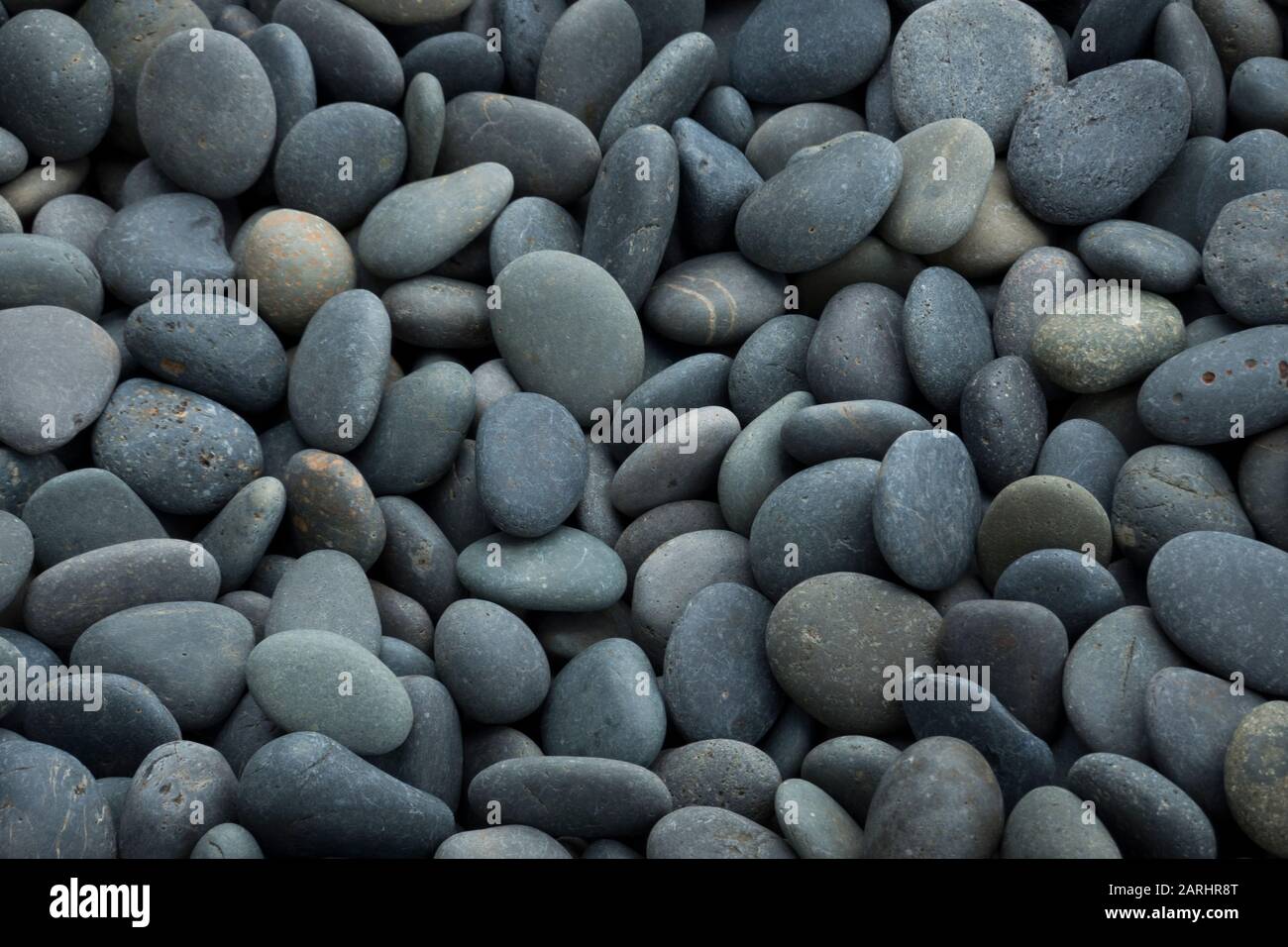 polished black stones on beach Stock Photo - Alamy