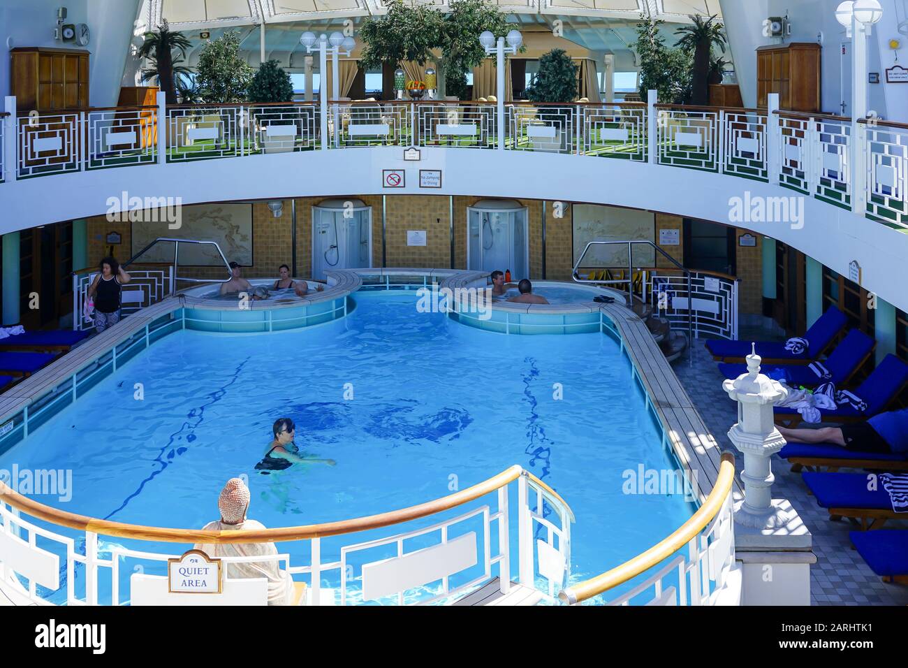 Cruise passengers enjoy sun and pool on deck of luxurious Cruise ship ...