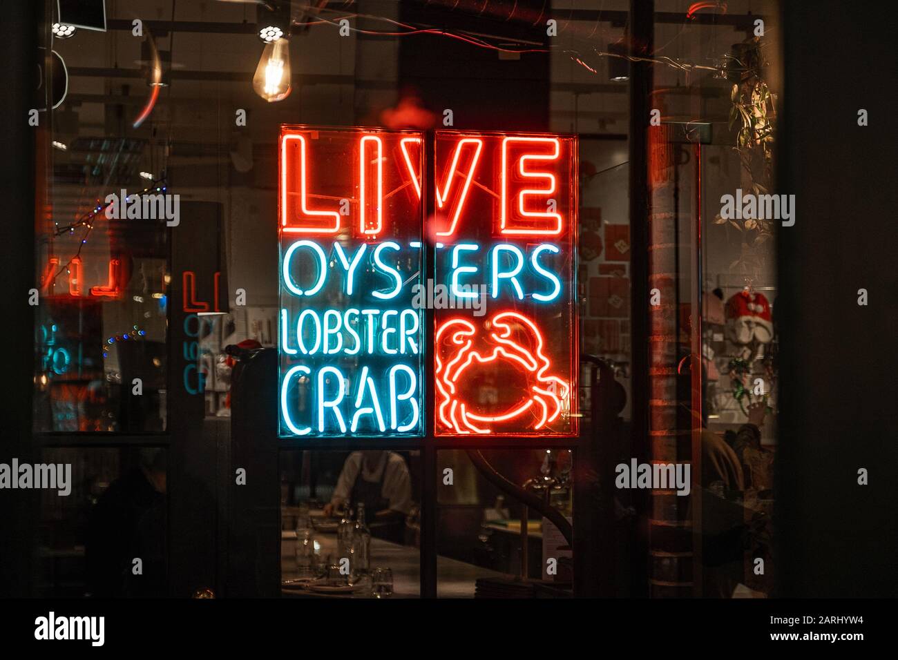 "Live oysters lobster crab" neon sign in a restaurant Stock Photo - Alamy