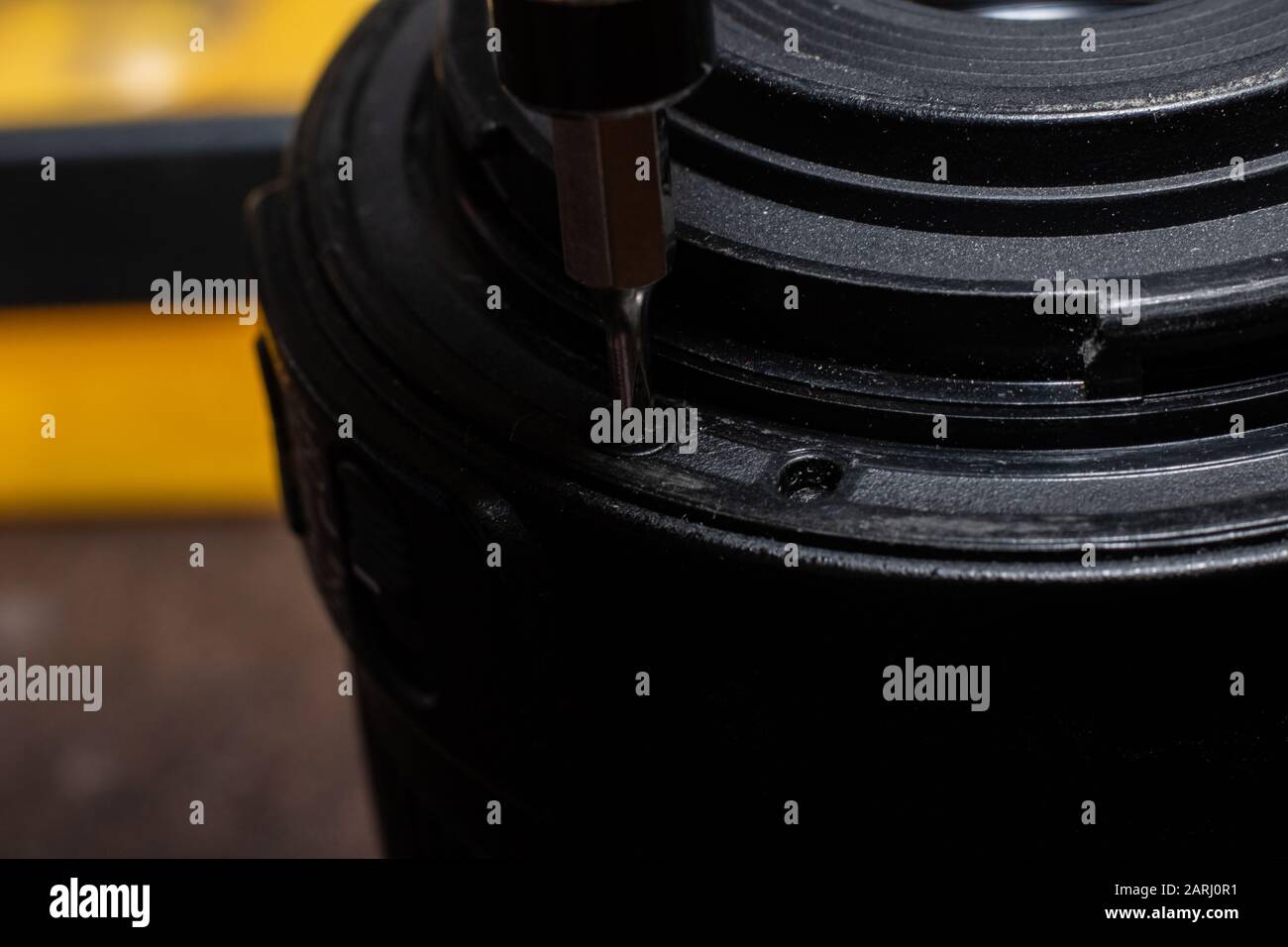 Tightening the bolt with a screwdriver close up, camera lens repair ...