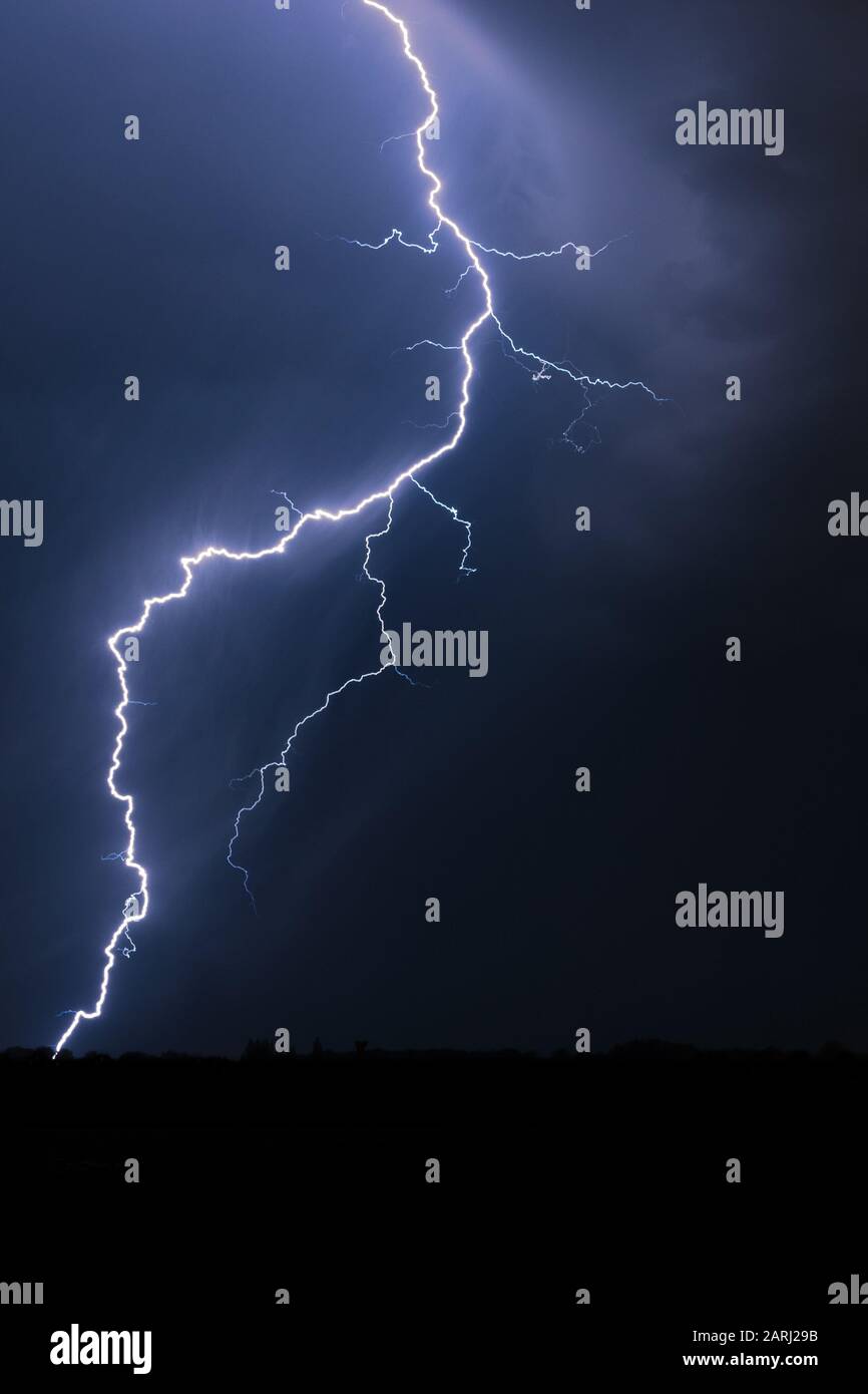 Vertical view of forked lightning bolt striking down to earth Stock ...