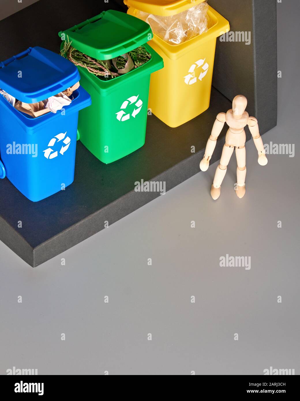 Wooden model of human and three color coded recycle bins, isometric ...
