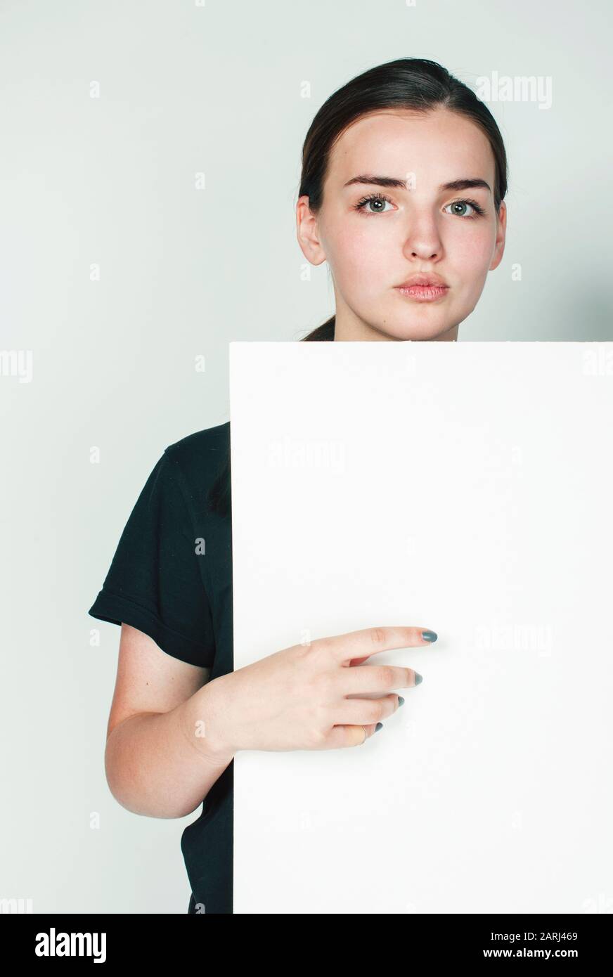 young pretty brunette girl with placard on white background wearing ...