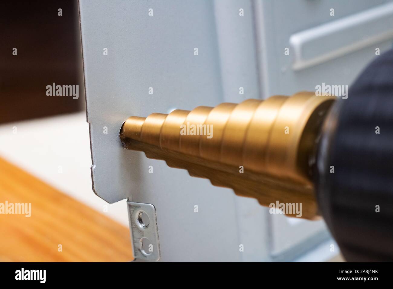 Multistage drill in sheet metal close up, macro photo Stock Photo - Alamy