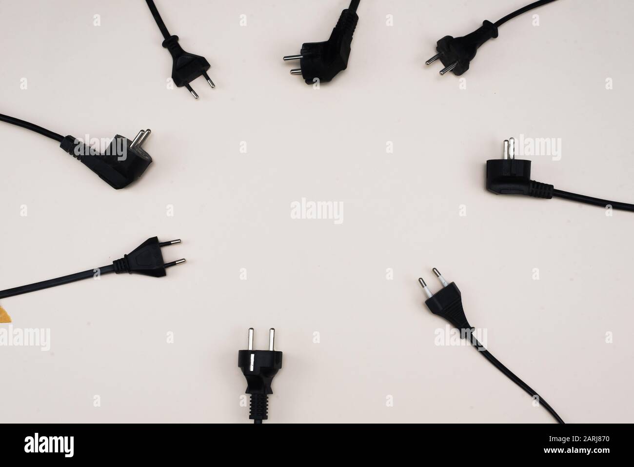 Wires with plugs lie on a white background in a circle. The concept of ...