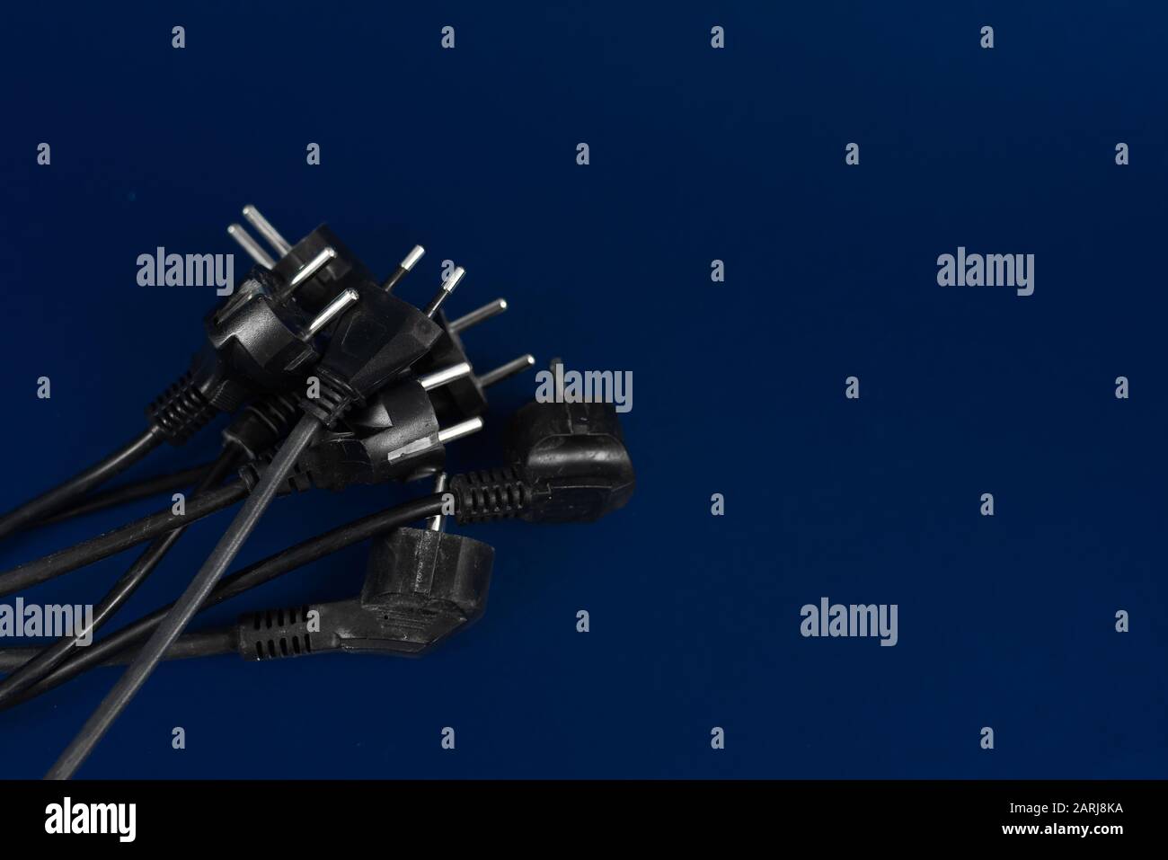 Old, used wires with plugs lie on a blue background. The concept of ...
