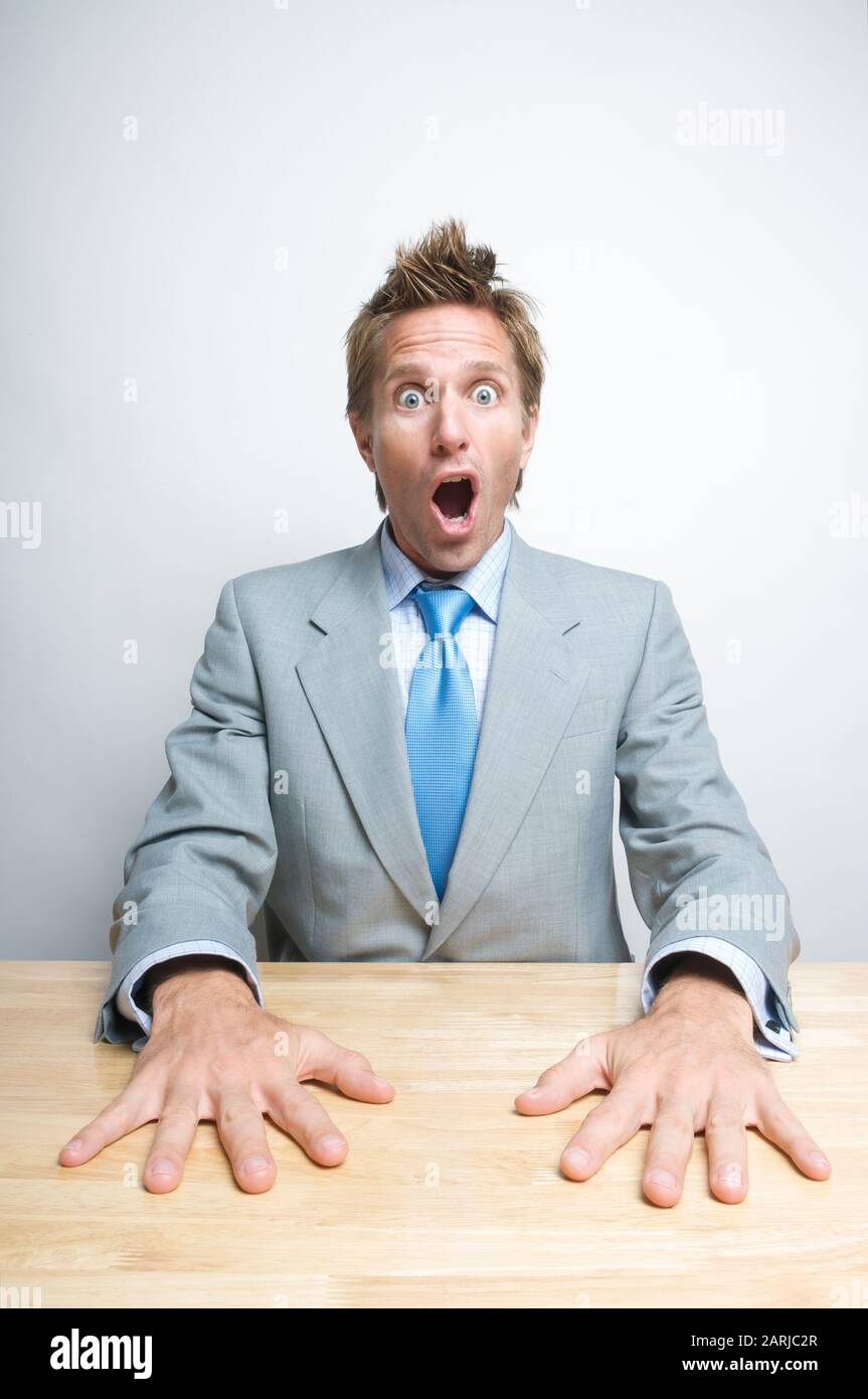 Office worker slapping his hands on the desk with an open mouth ...