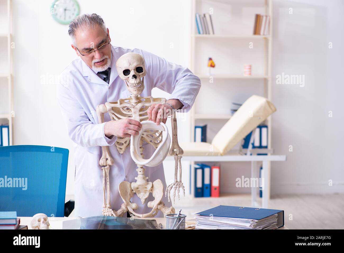 The aged male doctor with skeleton Stock Photo - Alamy