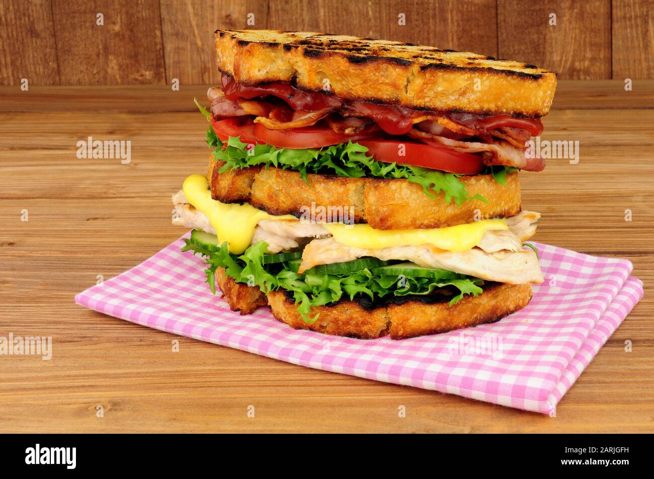 Chicken and bacon double decker sandwich on a wood background Stock ...