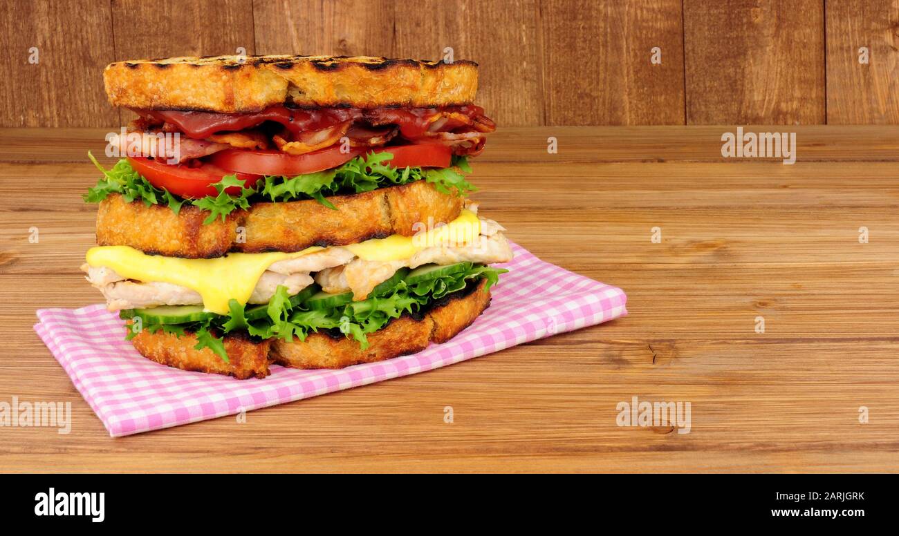 Chicken and bacon double decker sandwich on a wood background Stock ...