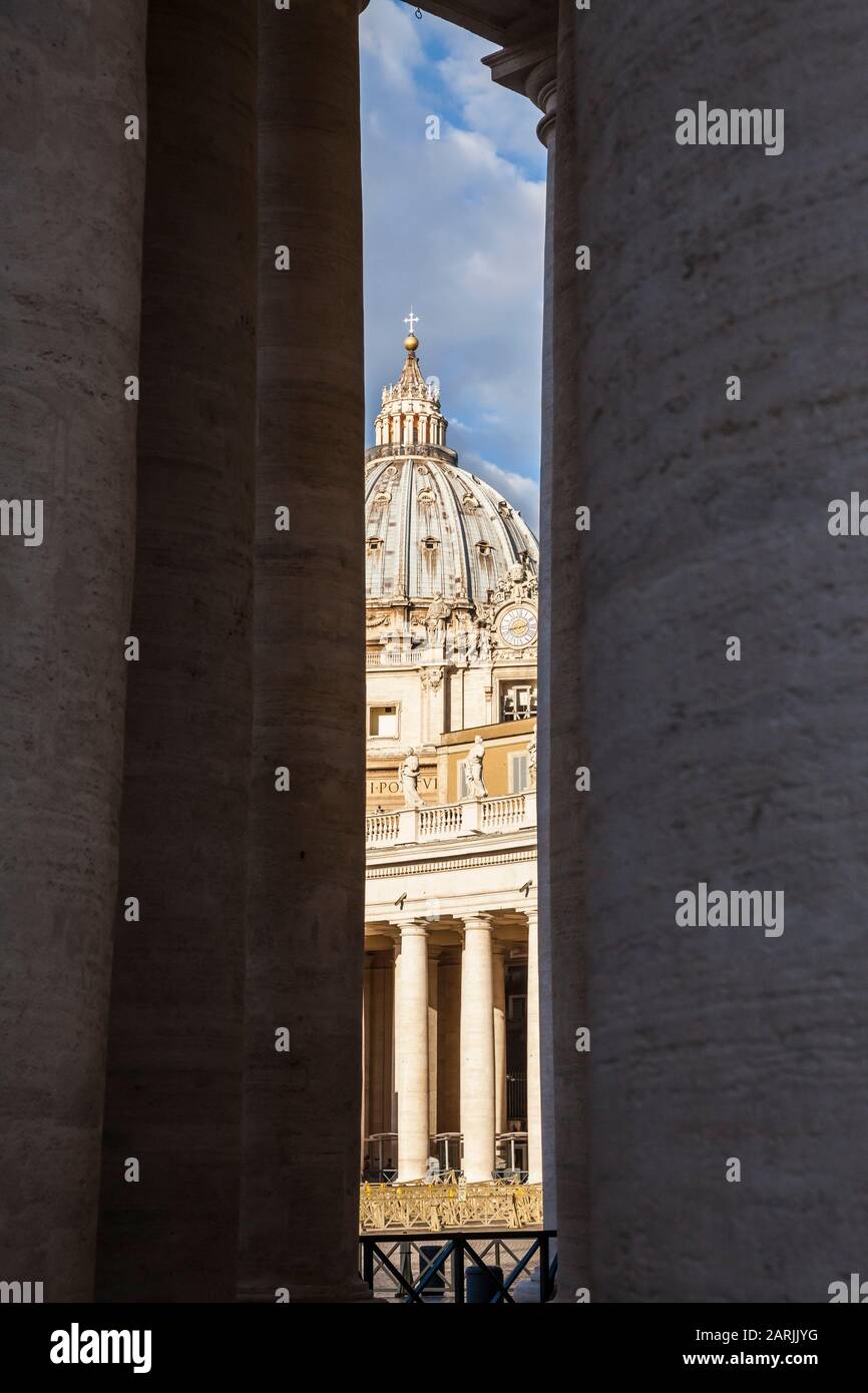 A view of St. Peters Basilica between the pillars of the colonnade ...