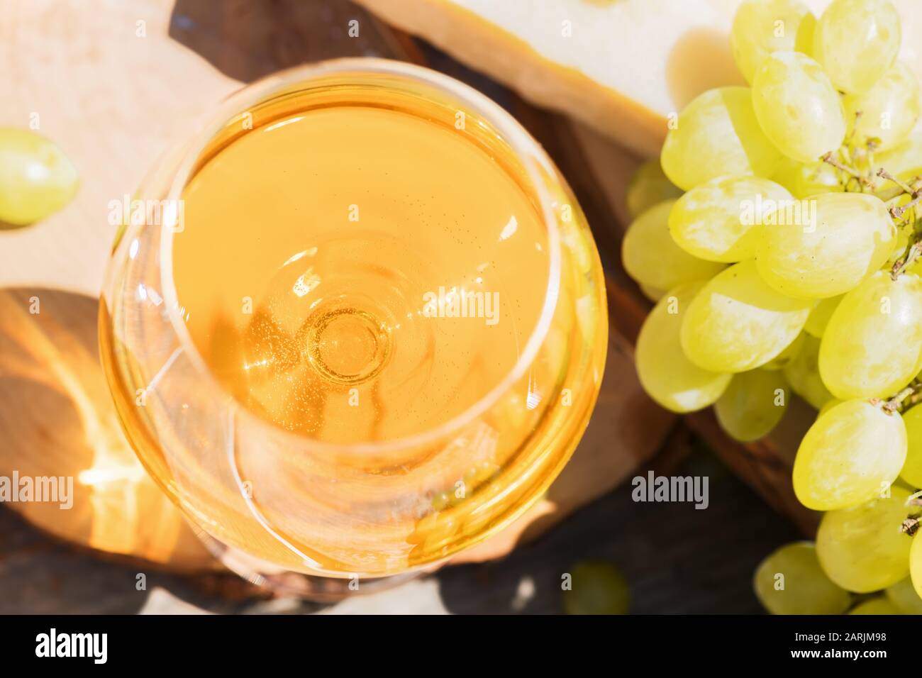 Amber wine in glasses on the nature: still life with cheese, grapes and ...