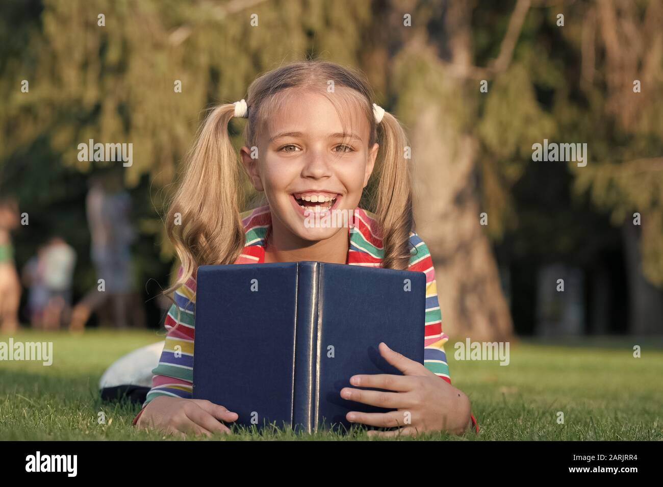 My education came from encyclopedia. Happy little girl read ...