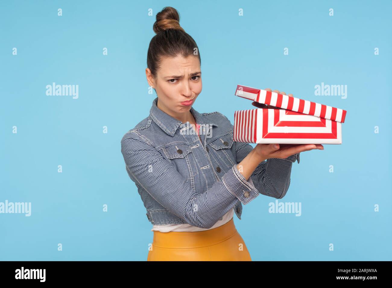 Bad gift. Upset frustrated woman in denim jacket unpacking present ...