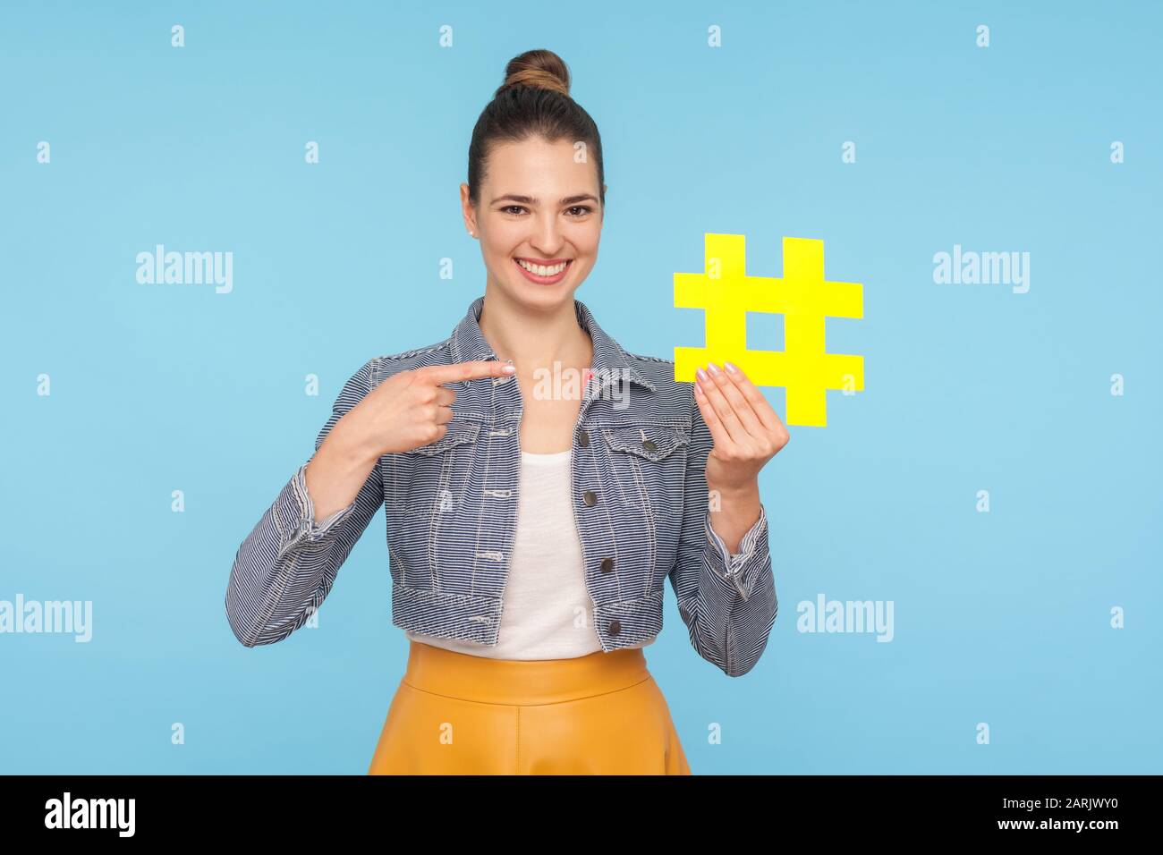 Optimistic happy attractive woman with hair bun in stylish outfit ...