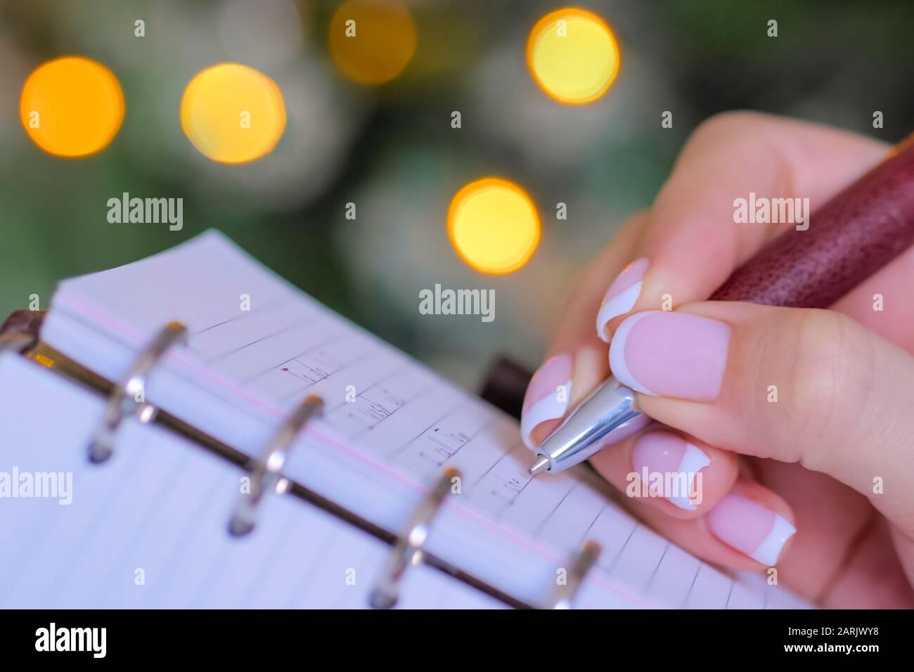 Woman hand holding pen and writing to do list in vintage notebook ...