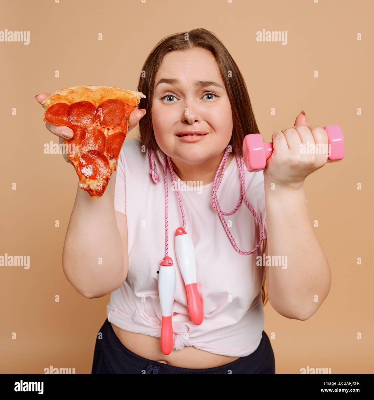 Woman choosing between pizza and exercises. Getting rid of junk food ...