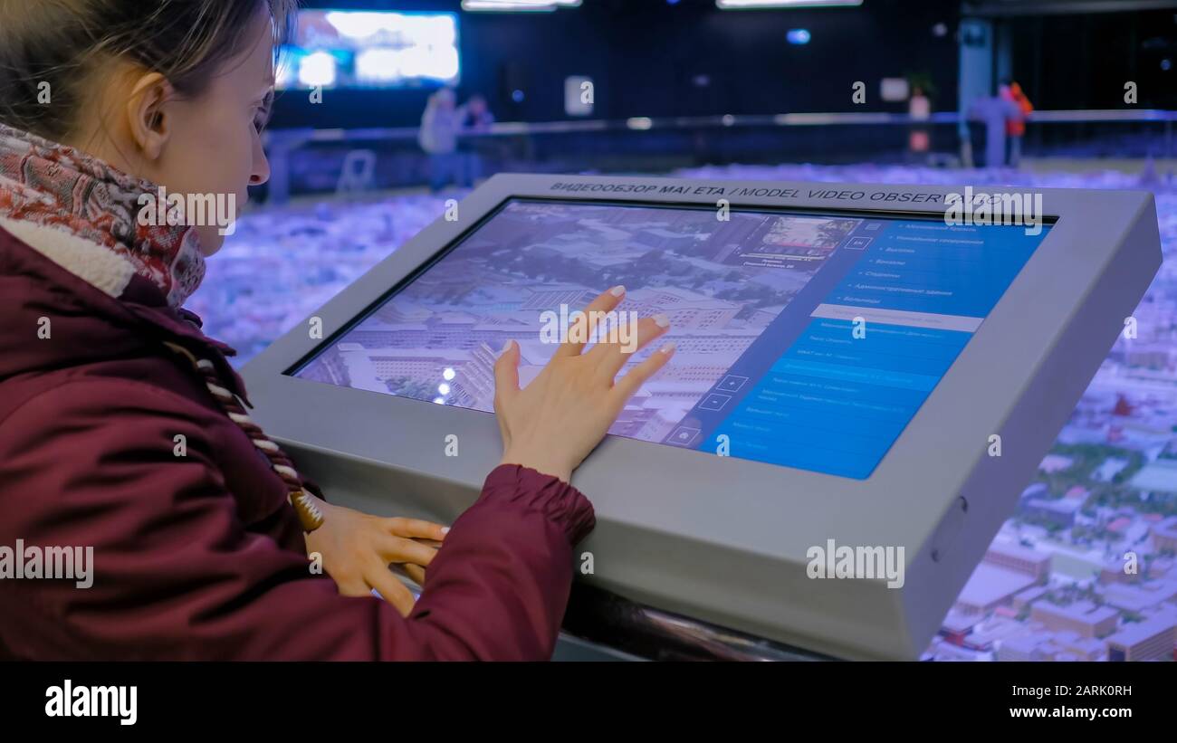 Woman using interactive touchscreen display at modern museum or ...