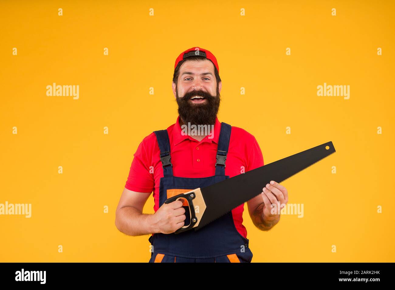 He fix everything. Builder working with saw. brutal male worker with ...