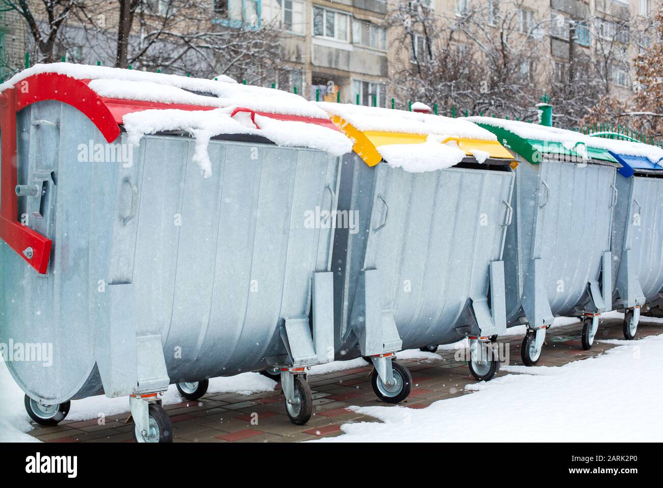 Trash bins for sorting garbage are standing on the street covered with ...