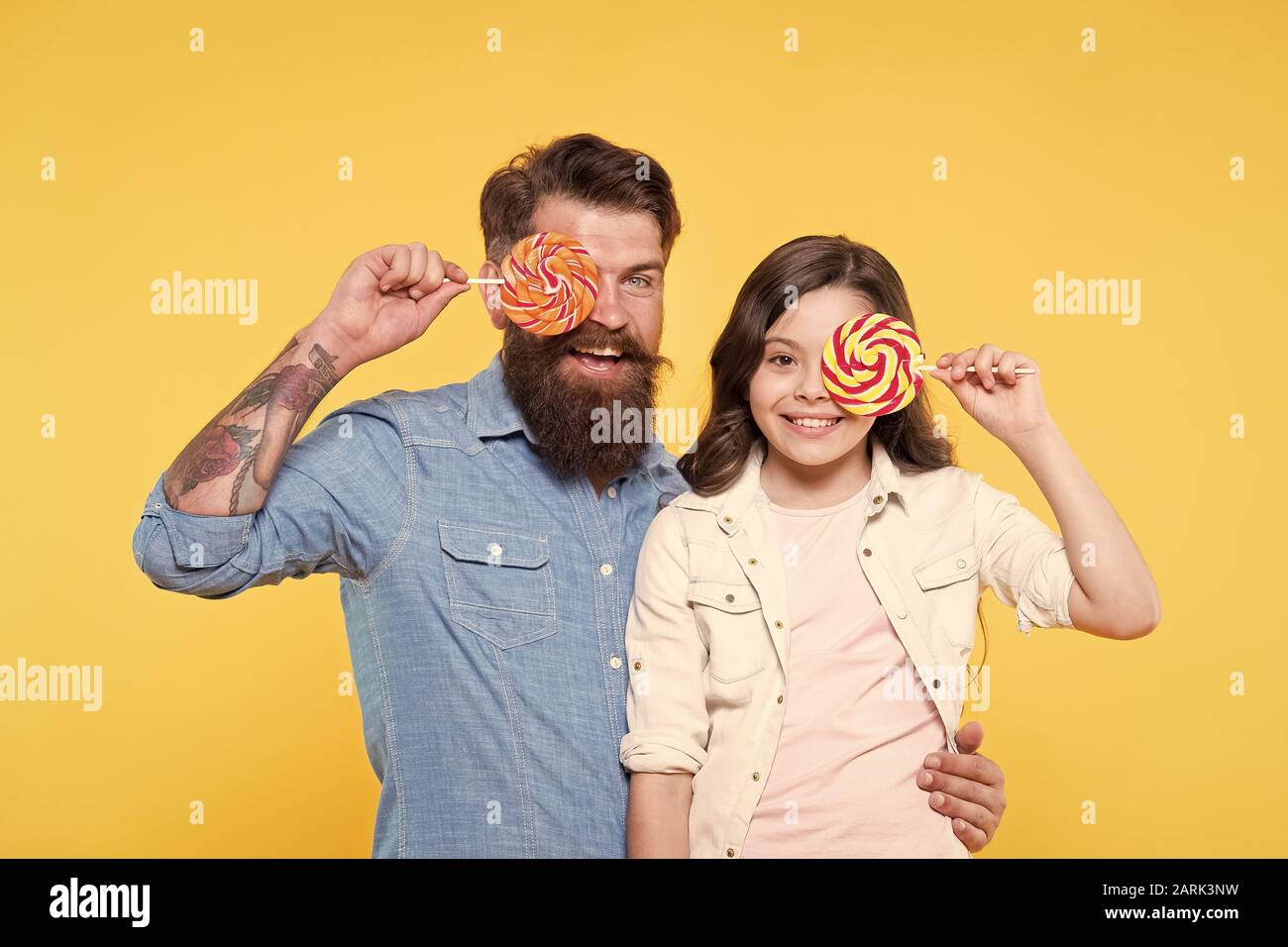 Sweet childhood. Girl child and dad hold colorful lollipops. Sweet ...