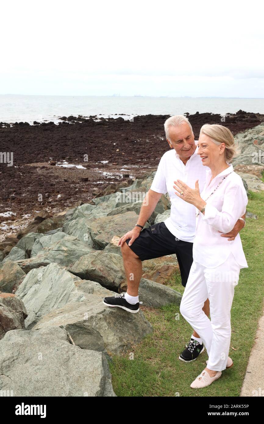 Mature married couple: As they stand together looking out over the ...