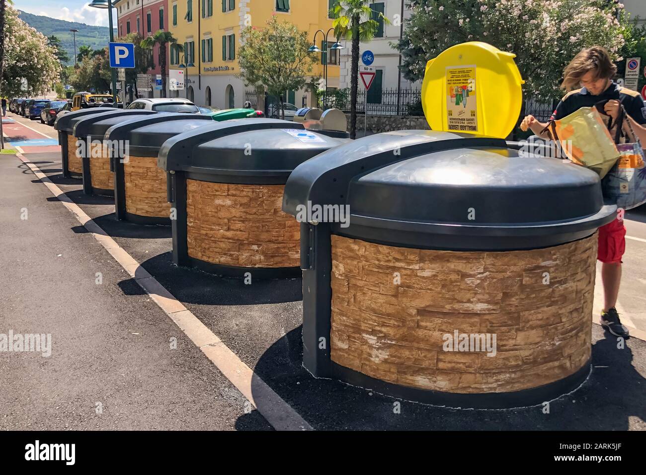 GARDA, ITALY - AUGUST 08, 2019: A man distributes garbage in different ...