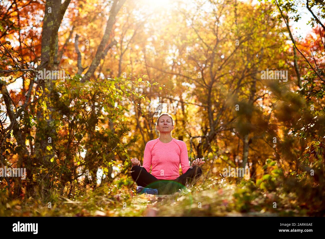 A woman meditates outdoors on a beautiful fall day Stock Photo - Alamy
