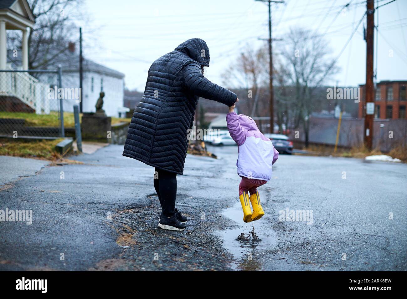 A mother and child having fun jumping in puddles Stock Photo - Alamy
