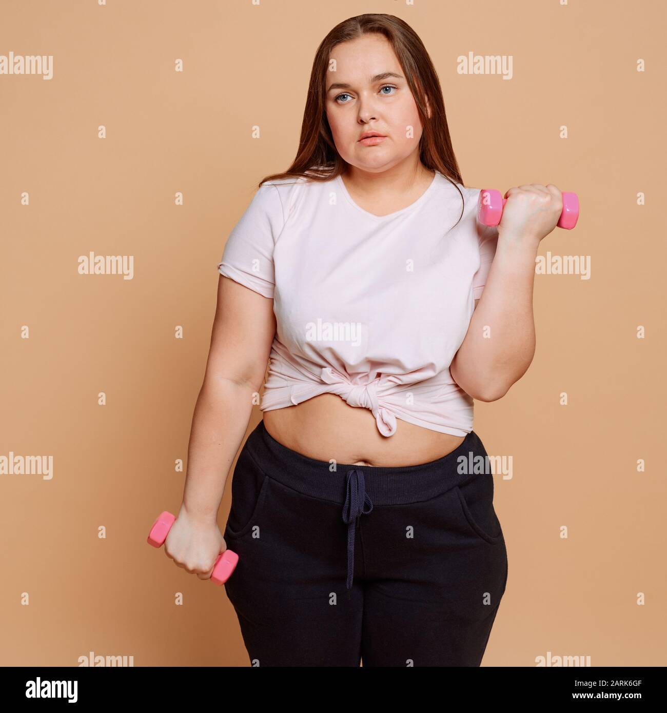 Bored overweight woman working out with dumbbells unwillingly Stock ...