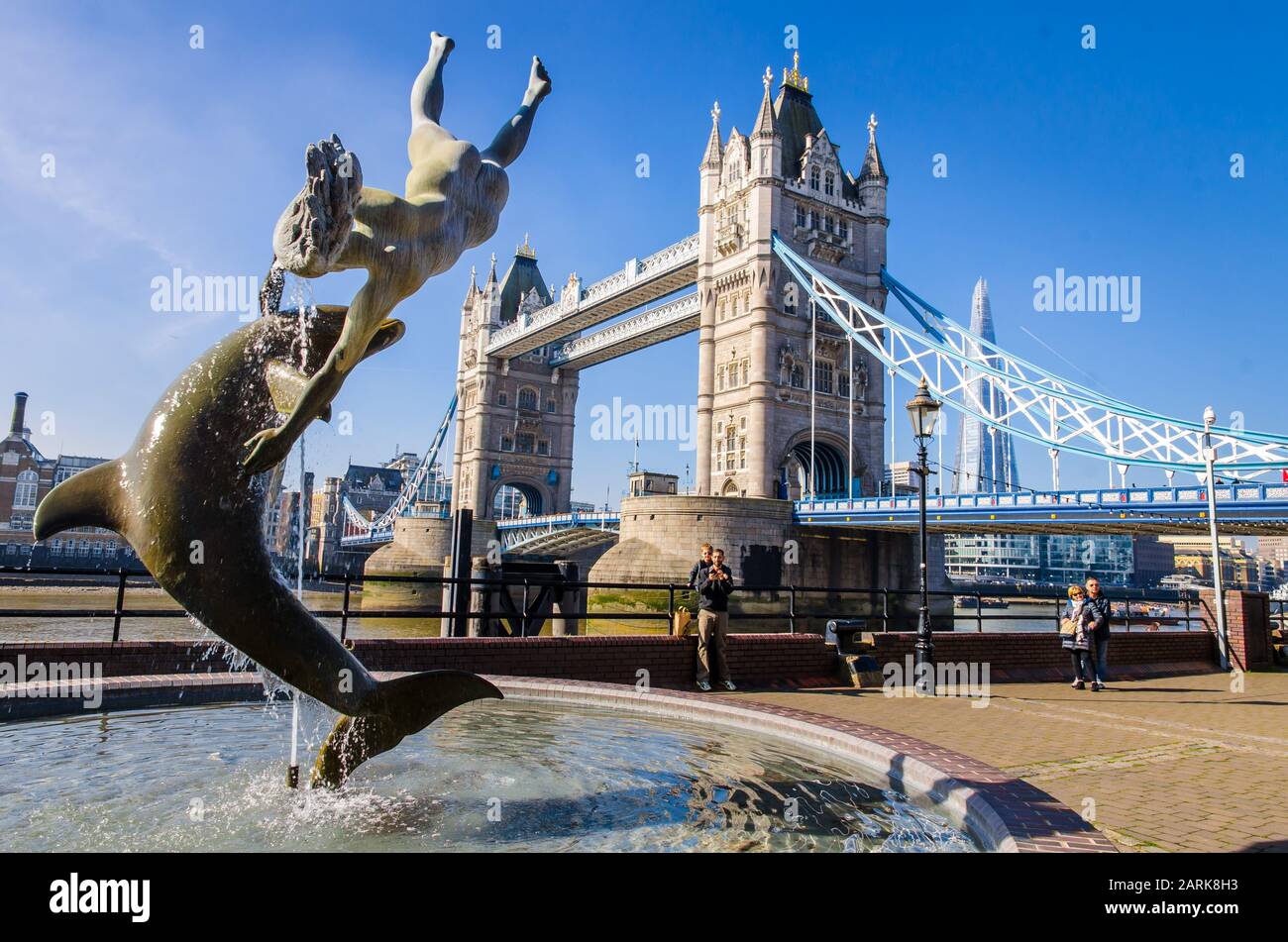 Tower bridge and the Girl with a dolphin fountain in a sunny London ...