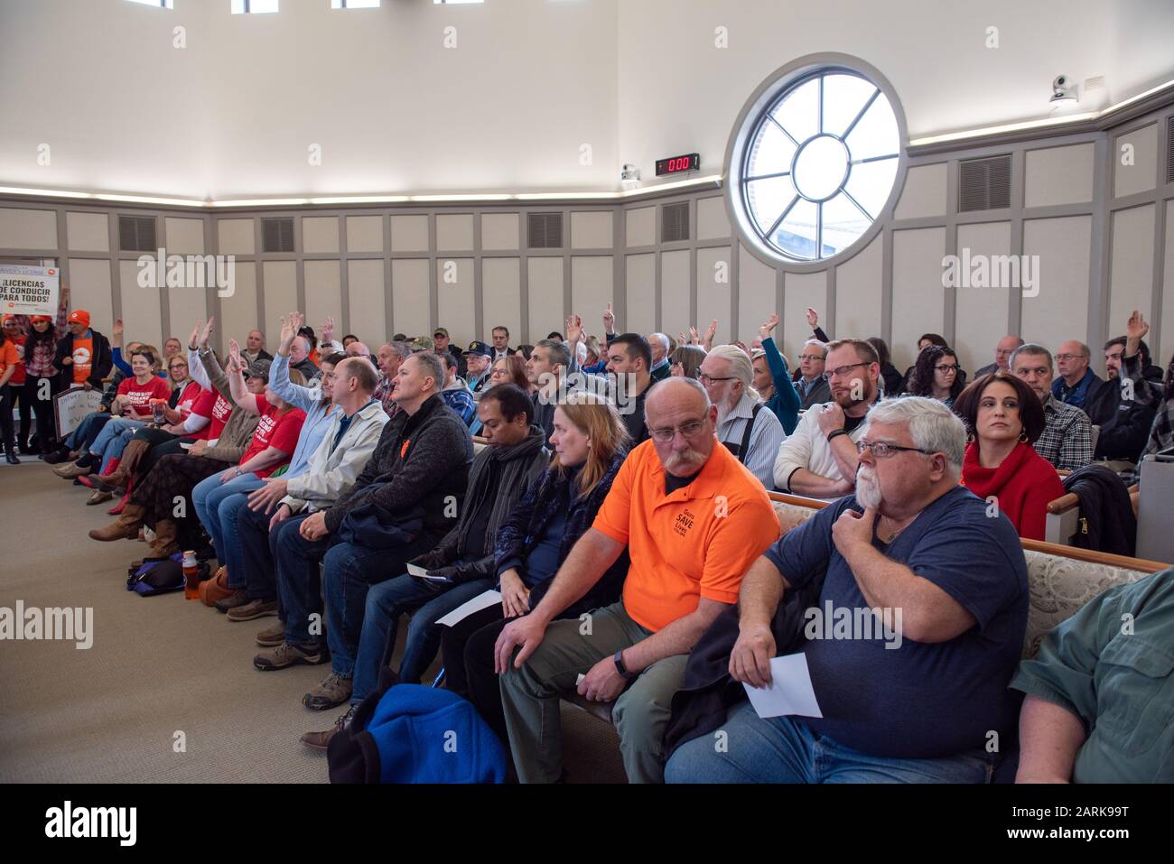 Leesburg, VA, USA--January 25, 2020. Residents raise thier hands to ...
