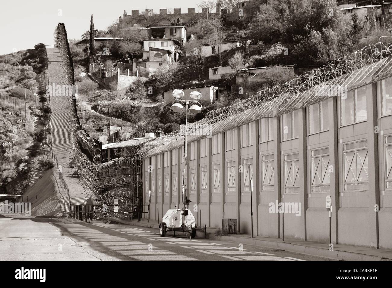 View of US/Mexico international border fence with razor wire following ...
