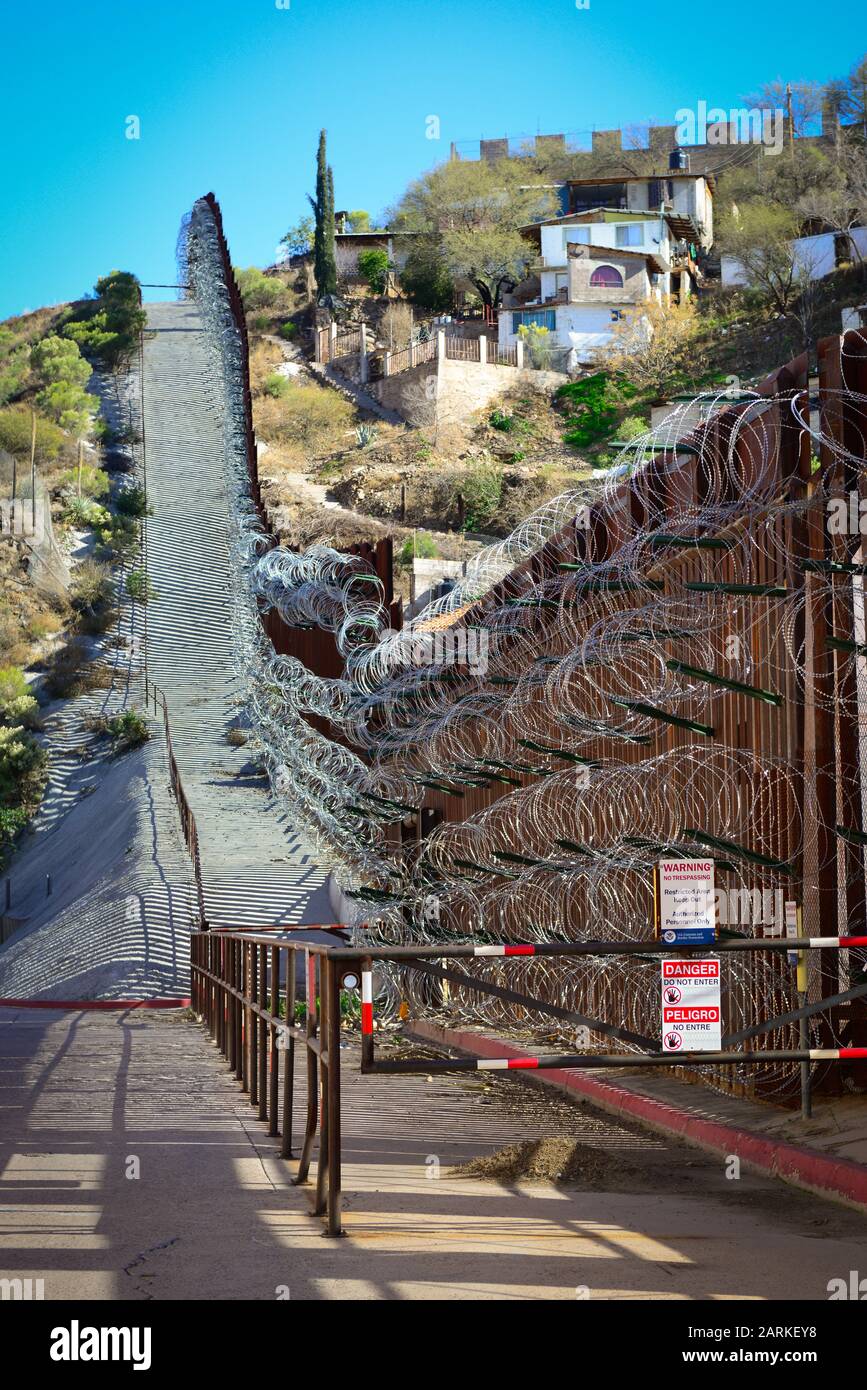 View of US/Mexico international border fence with razor wire following ...