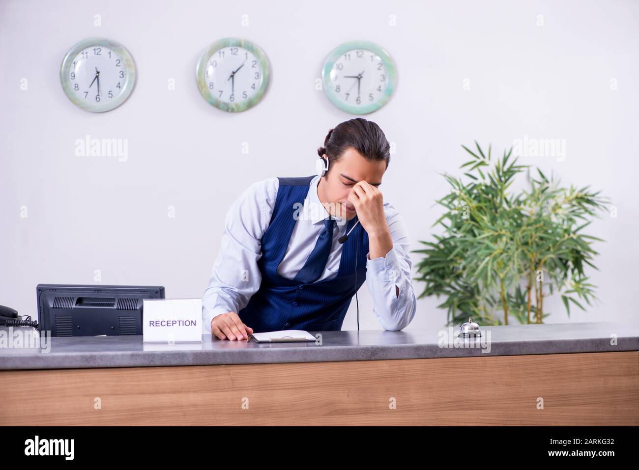 The young man receptionist at the hotel counter Stock Photo - Alamy