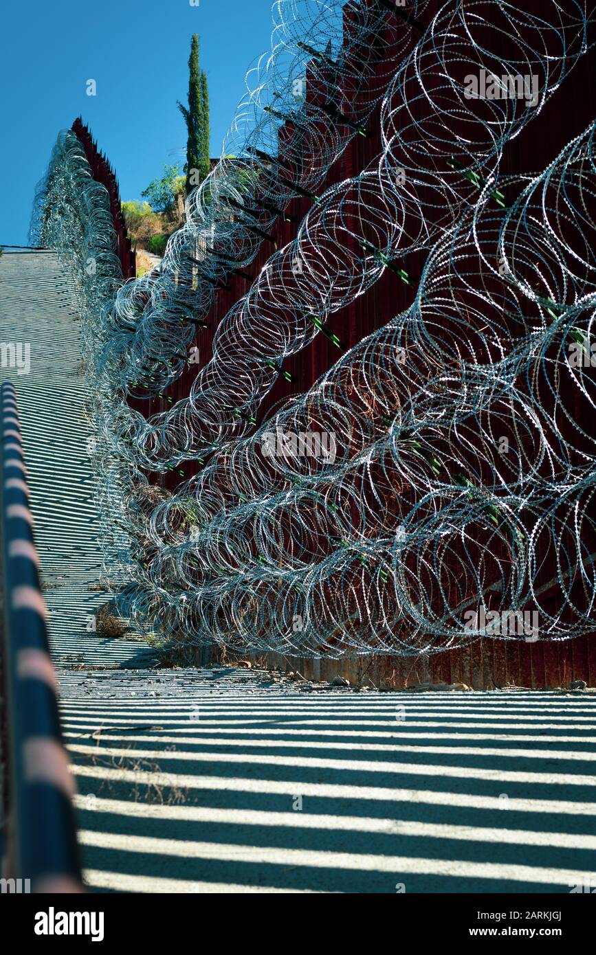 View of US/Mexico international border fence with razor wire following ...