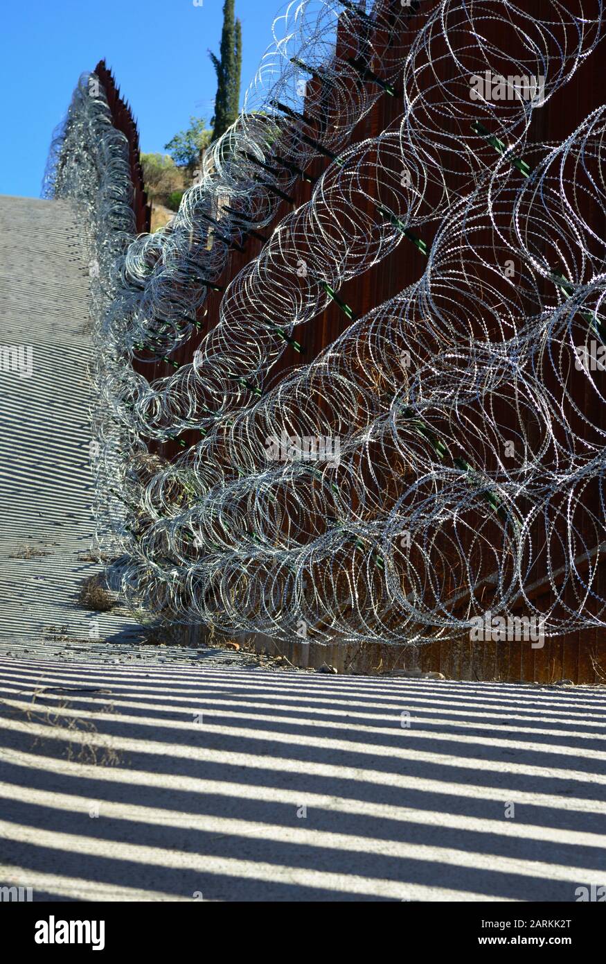 View of US/Mexico international border fence with razor wire following ...