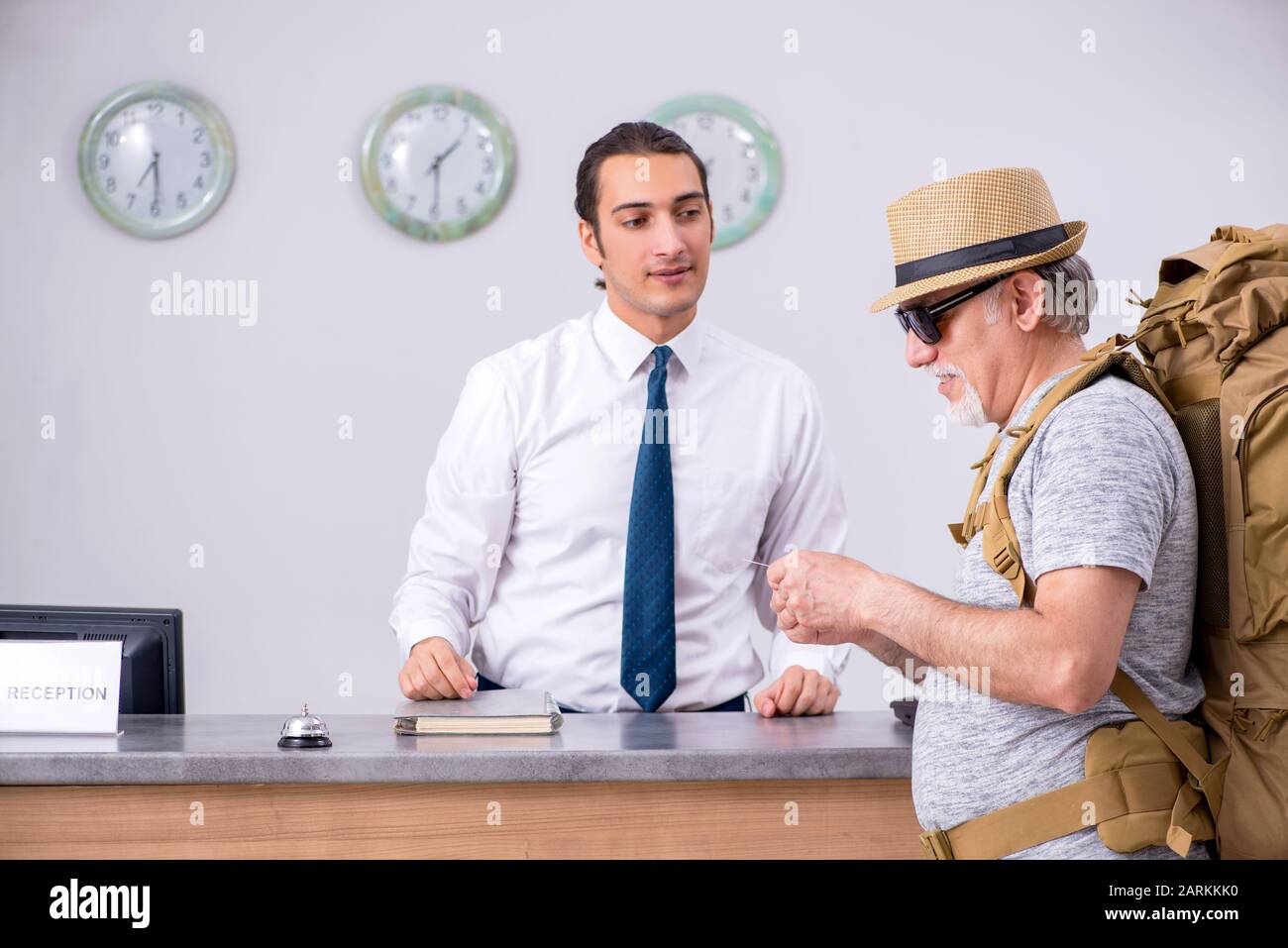 Old backpacker at the hotel reception Stock Photo - Alamy