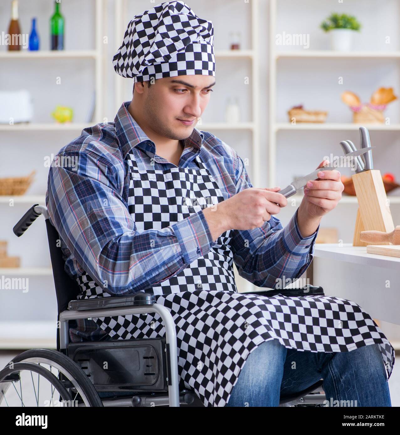 The disabled young man husband working in kitchen Stock Photo - Alamy