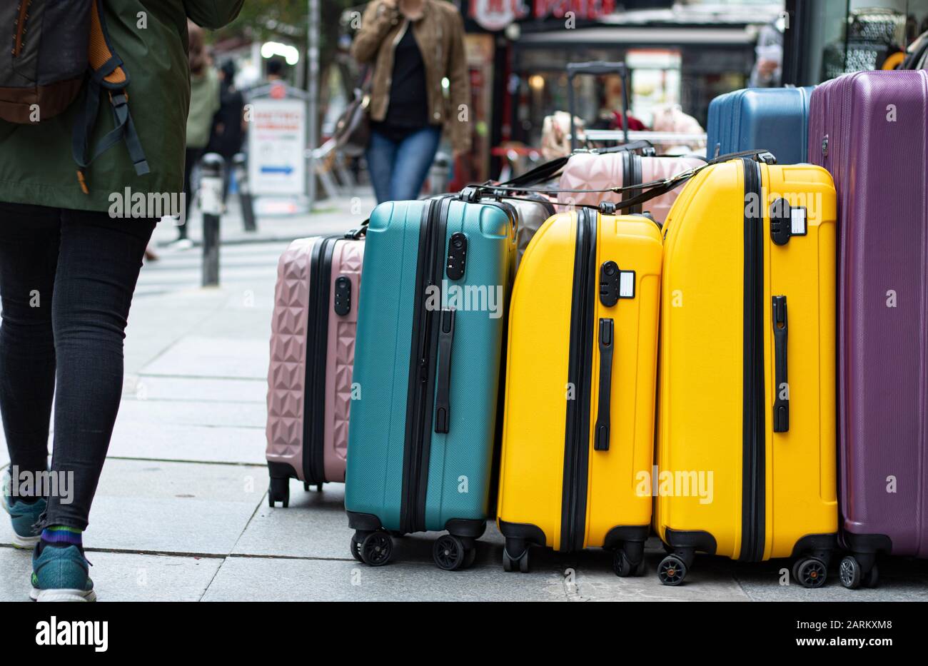 Close up of suitcases for sale on the pavement. Different colors and ...