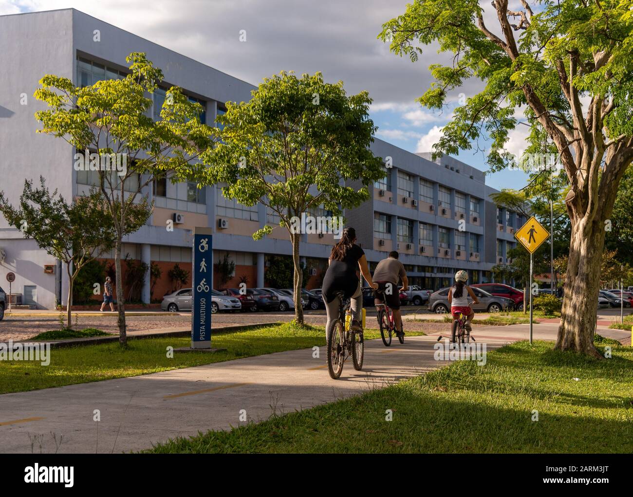 People riding a bicycle in Brazilian university. Cycling. Recreation ...