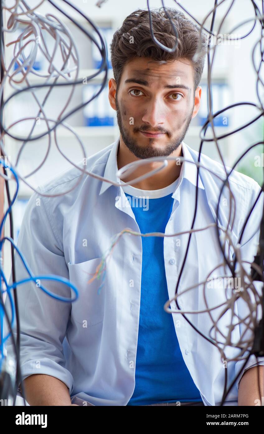The electrician trying to untangle wires in repair concept Stock Photo ...