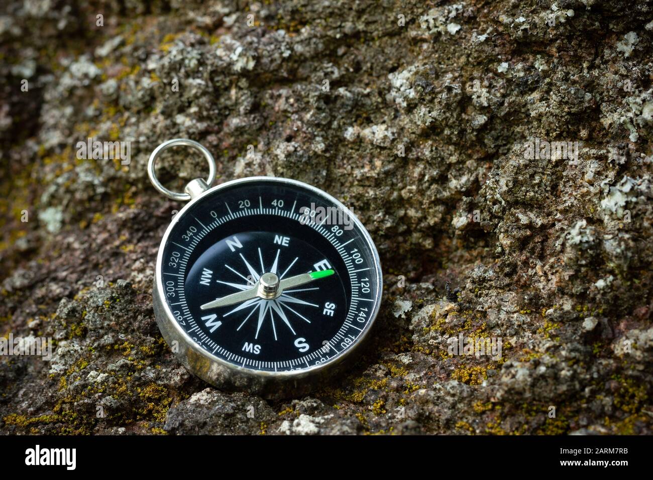 Compass placed on the rock in forest. Closeup and copy space. Concept ...