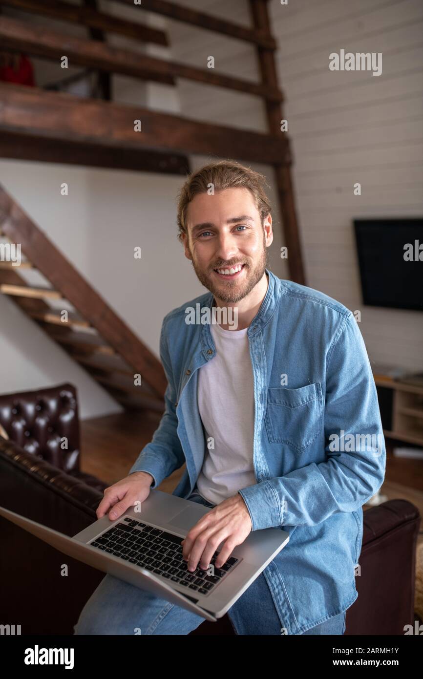 Smiling man working with his computer while staying at home Stock Photo ...