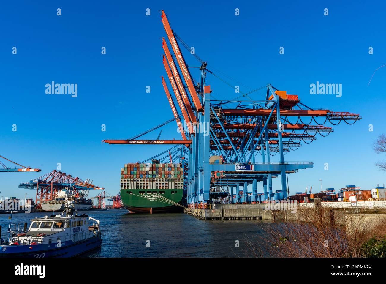 Hamburg container port with some ships loading and cranes transporting ...