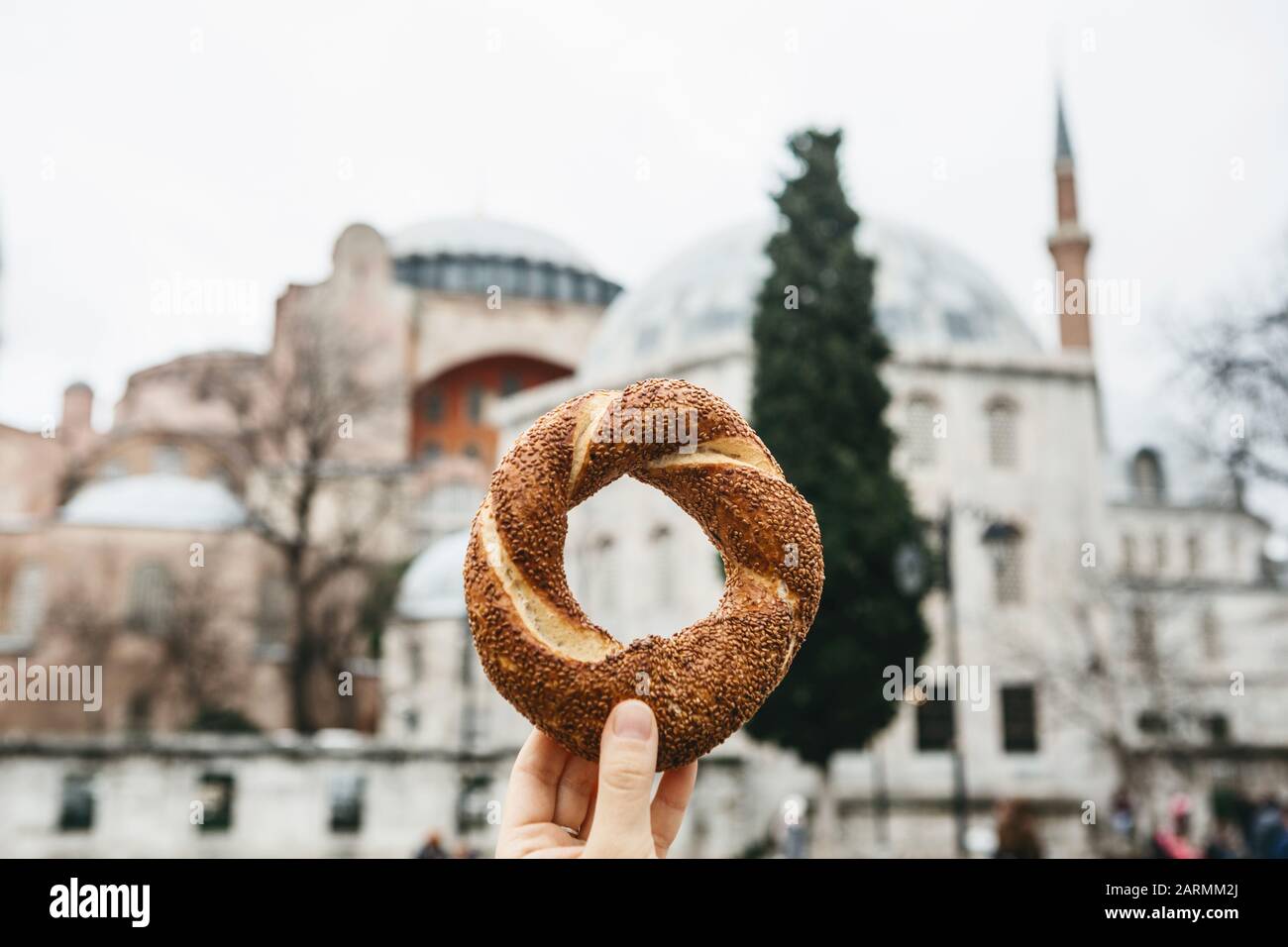 A person holds a traditional Turkish pretzel Simit against the ...